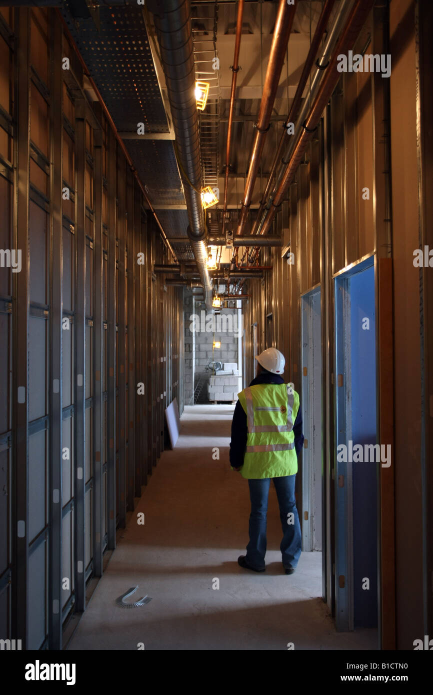 Construction worker in hard hat, high vis jacket inside a new ...