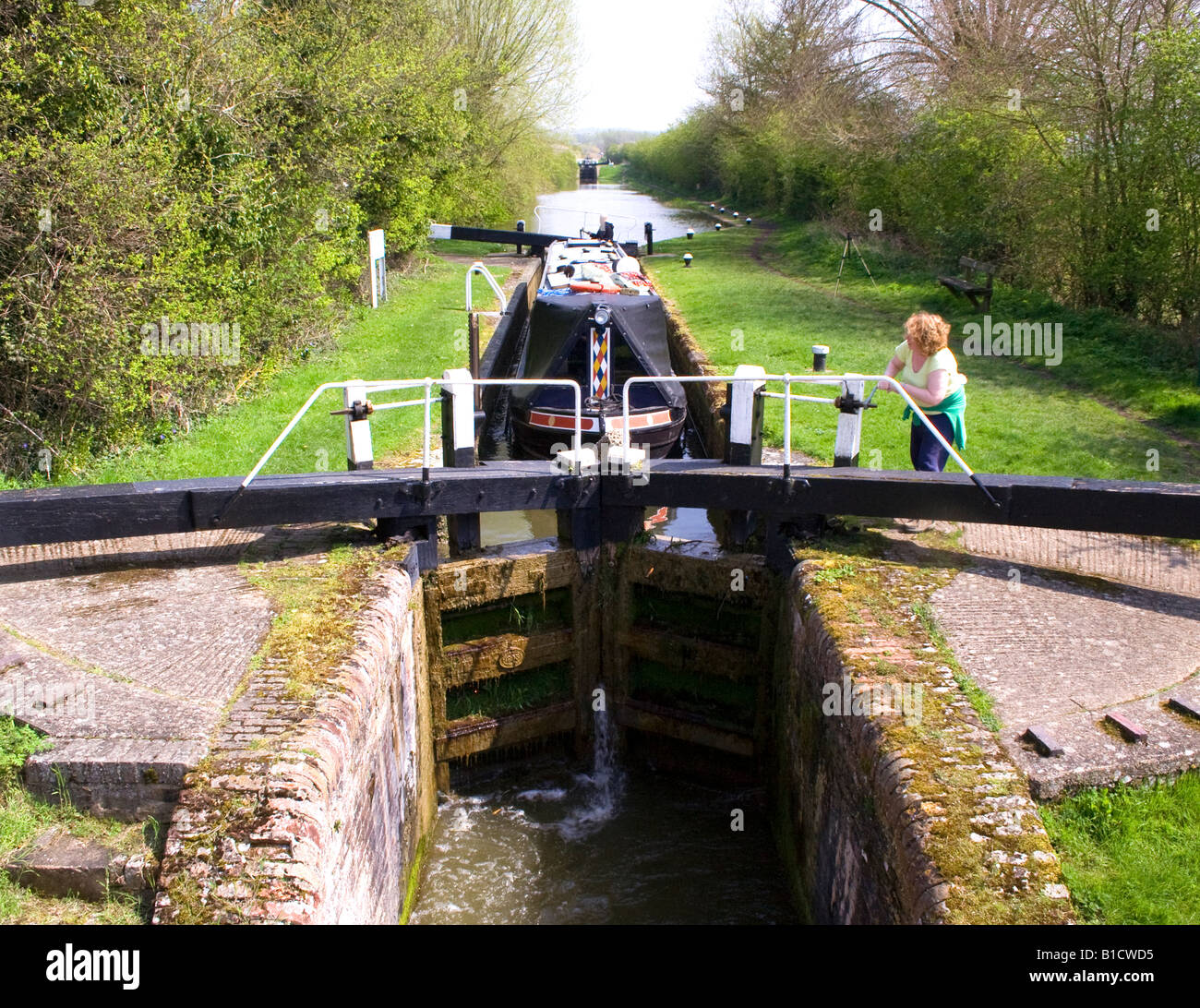 A narrow-boat in a canal lock on the Grand Union Canal with a woman ...