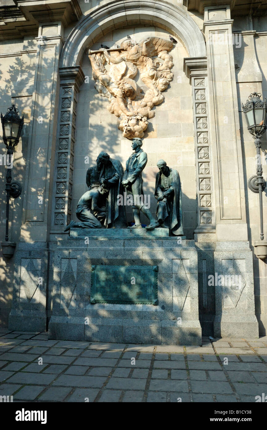 A bronze statueof three men and two priests with a sculpture of two ...