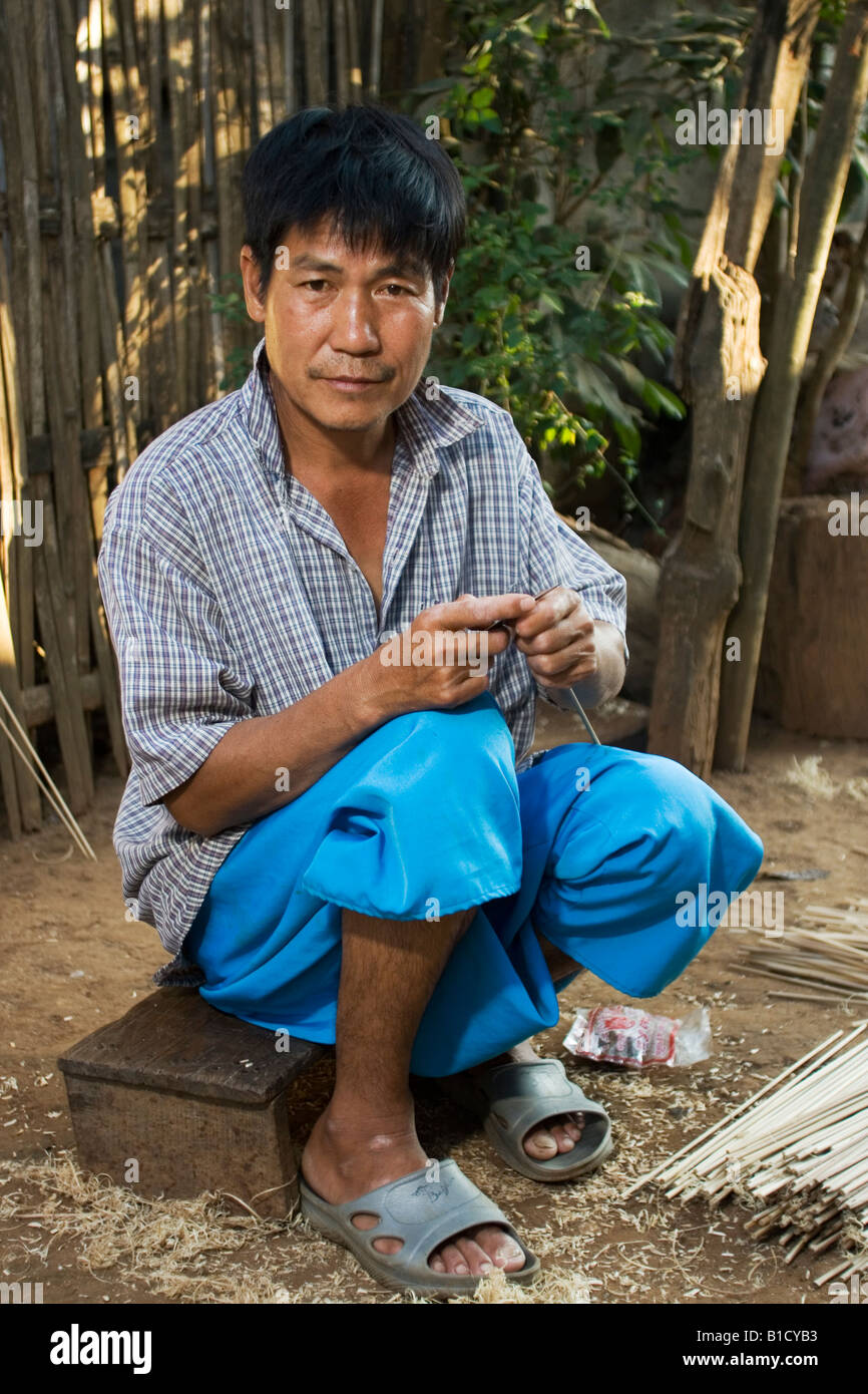 a member of the Lisu tribe outside his house making a basket Stock ...