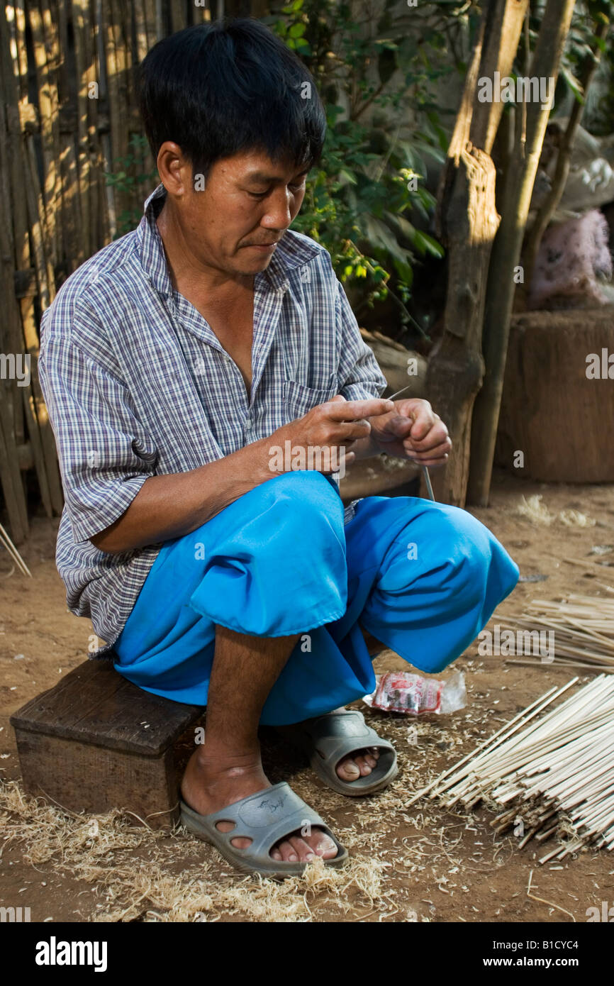 a member of the Lisu tribe outside his house making a basket Stock ...
