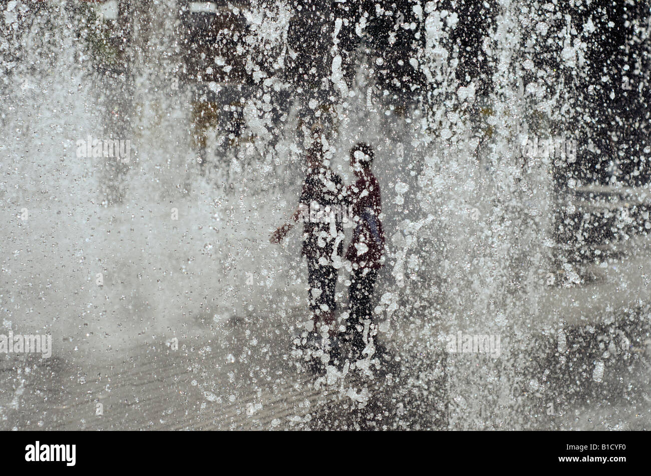 Two boys cooling themselves in the fountains outside City Hall in ...