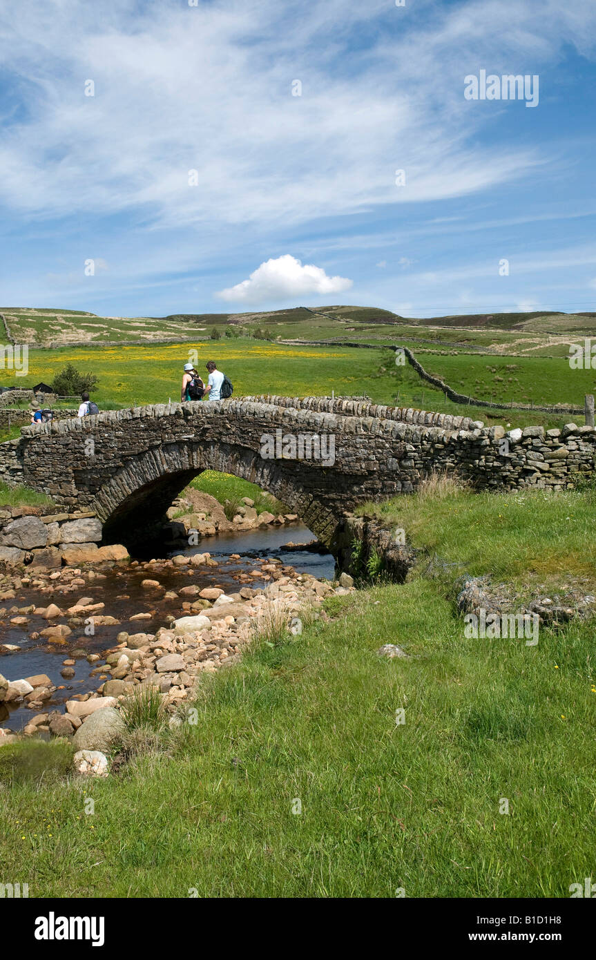Walkers on a Pack Horse Bridge, Ravenseat Farm, nr Keld, Swaledale ...