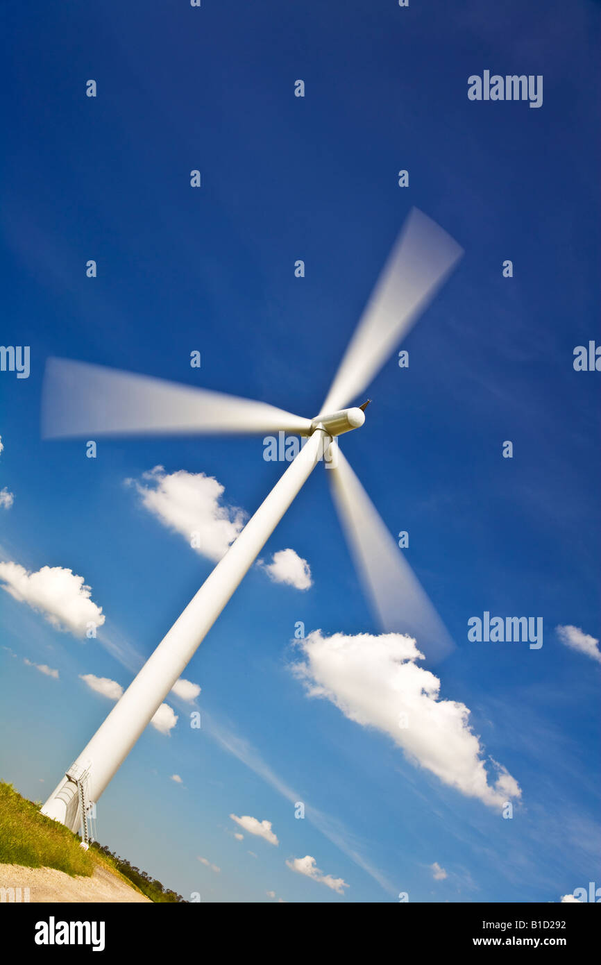Diagonal view of a wind turbine with baldes turning against a blue ...