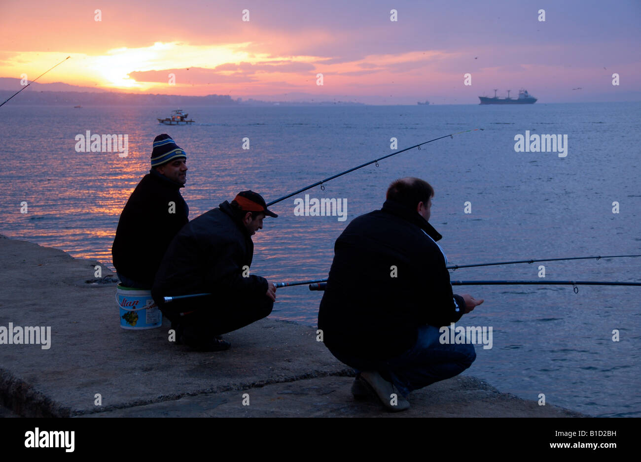 Three fisherman ply their trade as the sun rises over the Bosphorus one ...