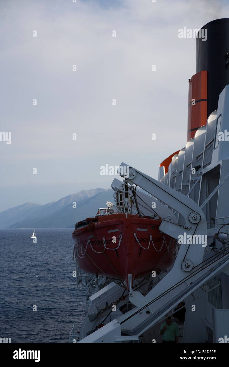 Starboard side of Cunard QE2 showing lifeboat and small sailing ship ...