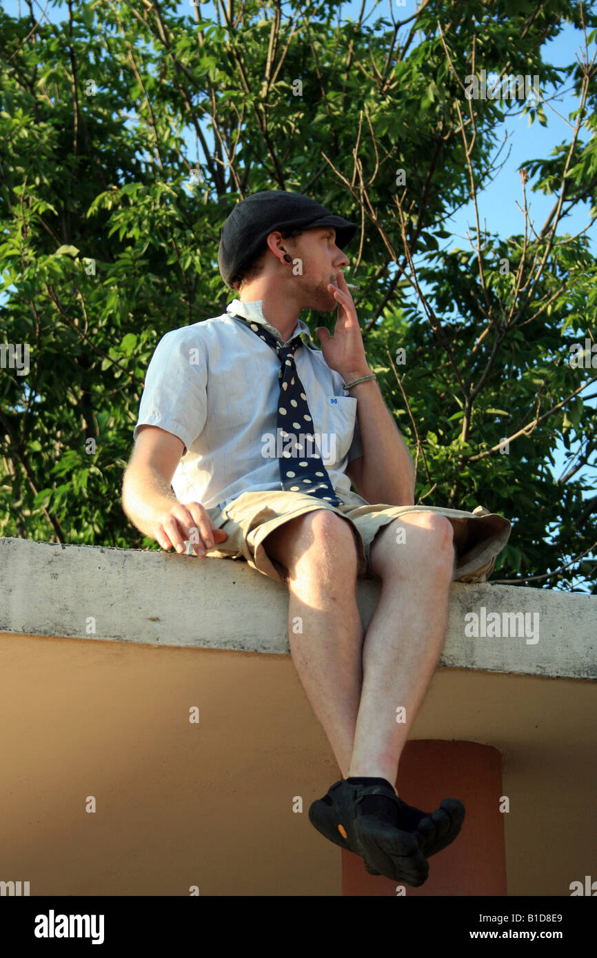 A young college student sits smoking on the roof of the art center at ...