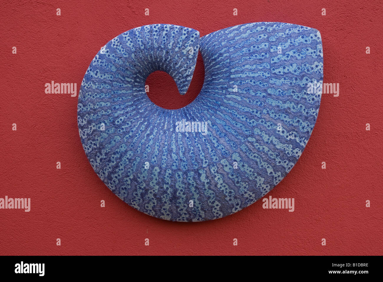 Sculpture of blue shell on red well Stock Photo - Alamy
