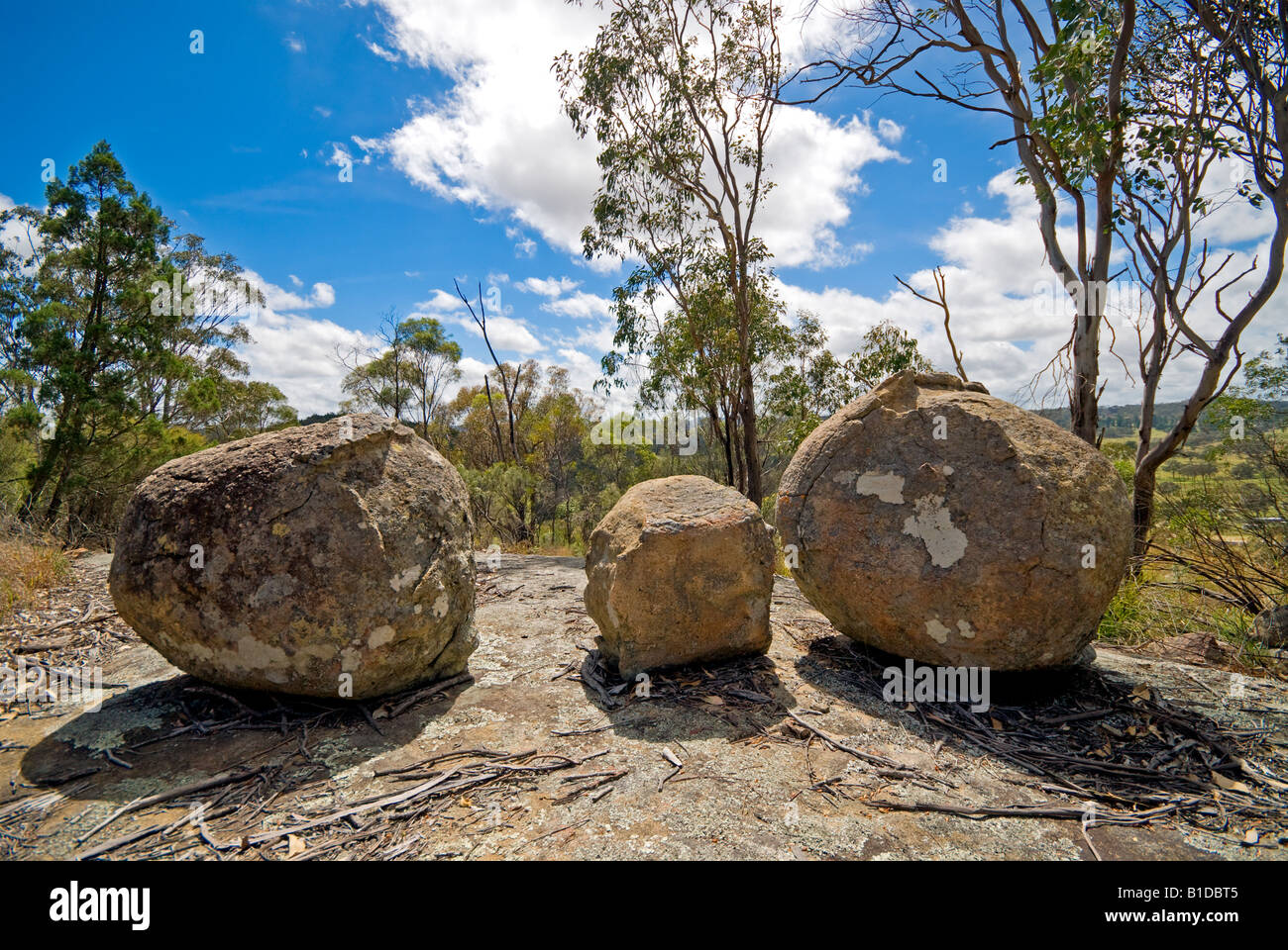 Three boulders in the Australian bush on a hill overlooking a valley ...
