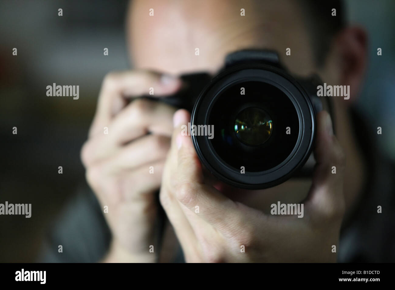 man holding a camera looking at the camera front view Stock Photo - Alamy