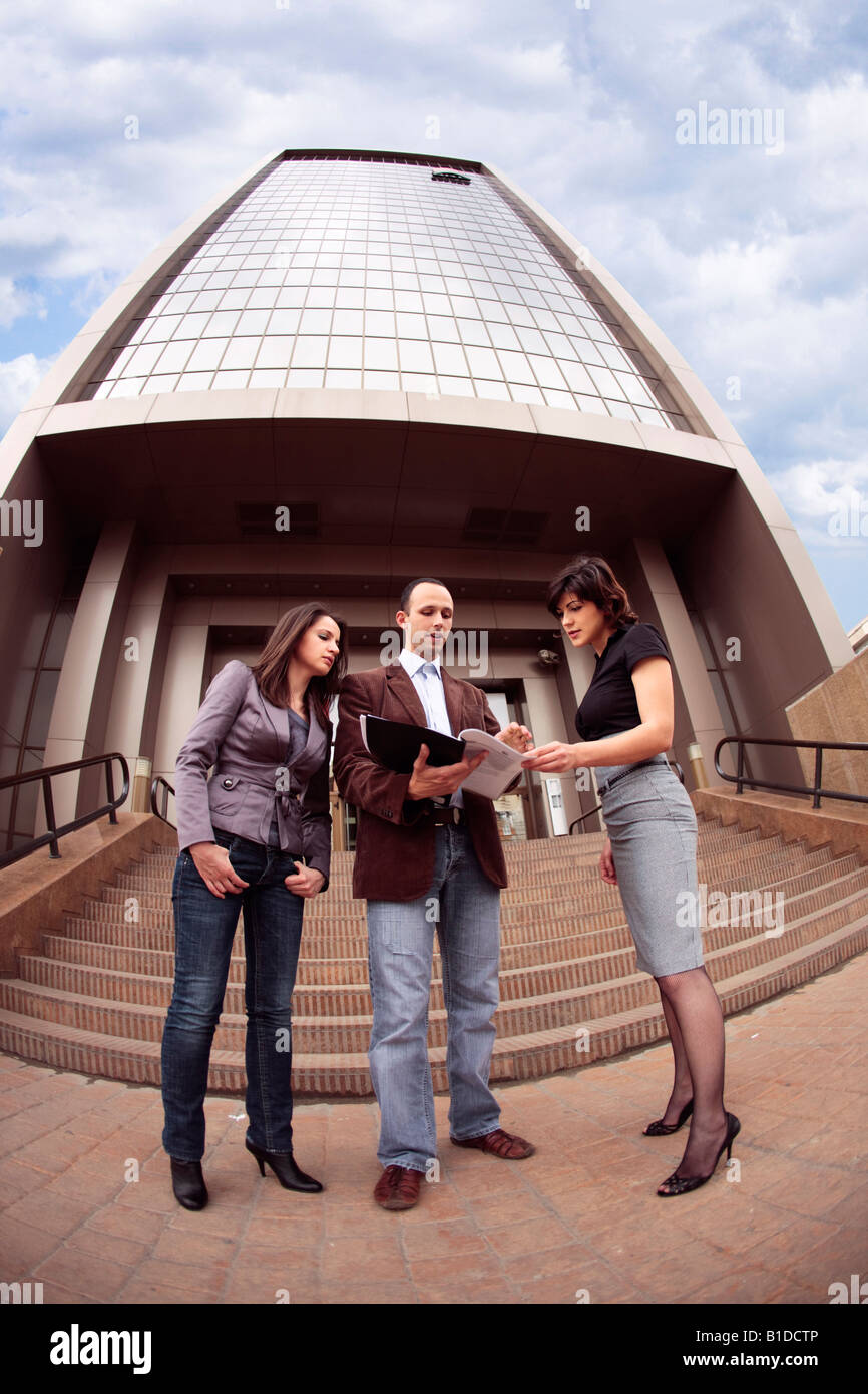 a fish eye look with business team talking outdoors in front of a sky ...