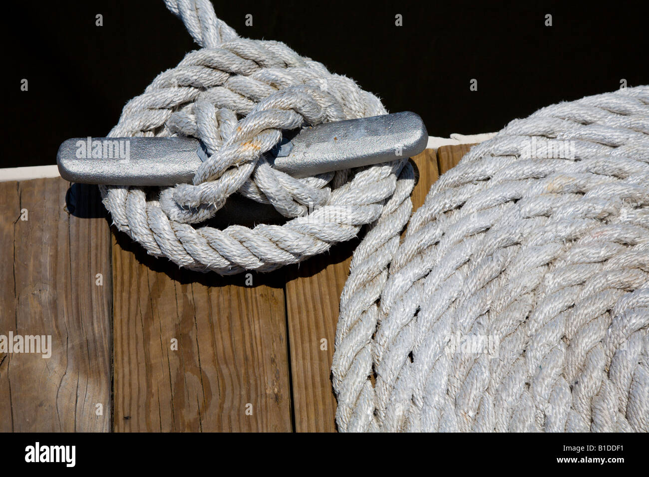 Sailing lines coiled neatly on dock next to cleat Stock Photo - Alamy