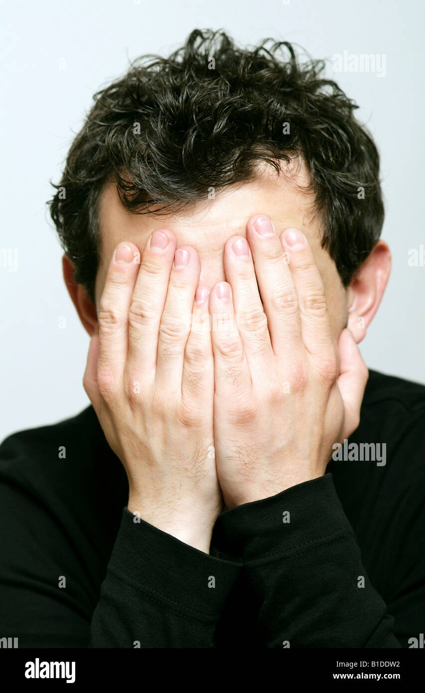 Man covering his face with his hands Stock Photo - Alamy