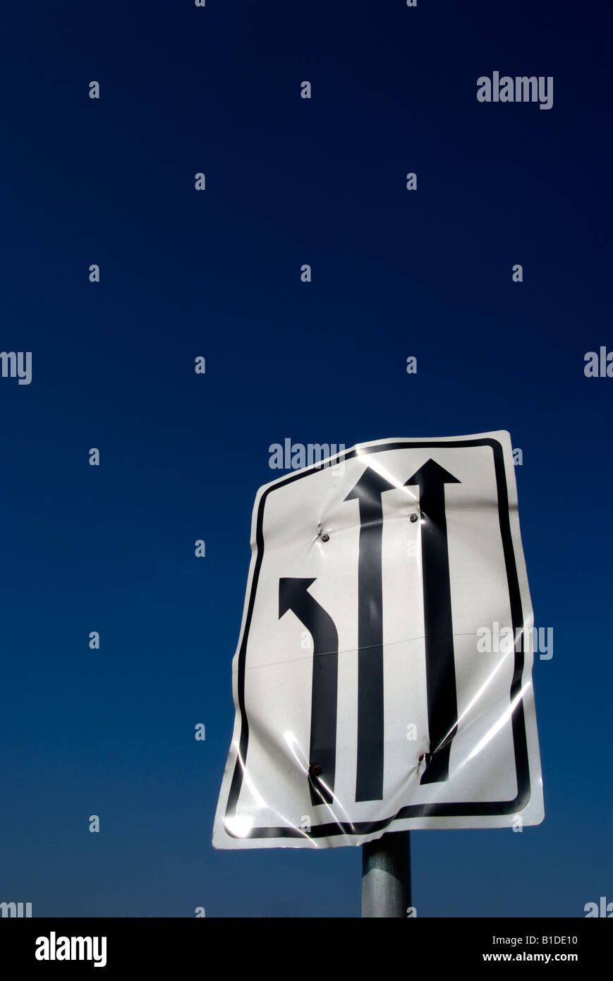 Bashed and battered road sign showing traffic flow in a school drop off ...