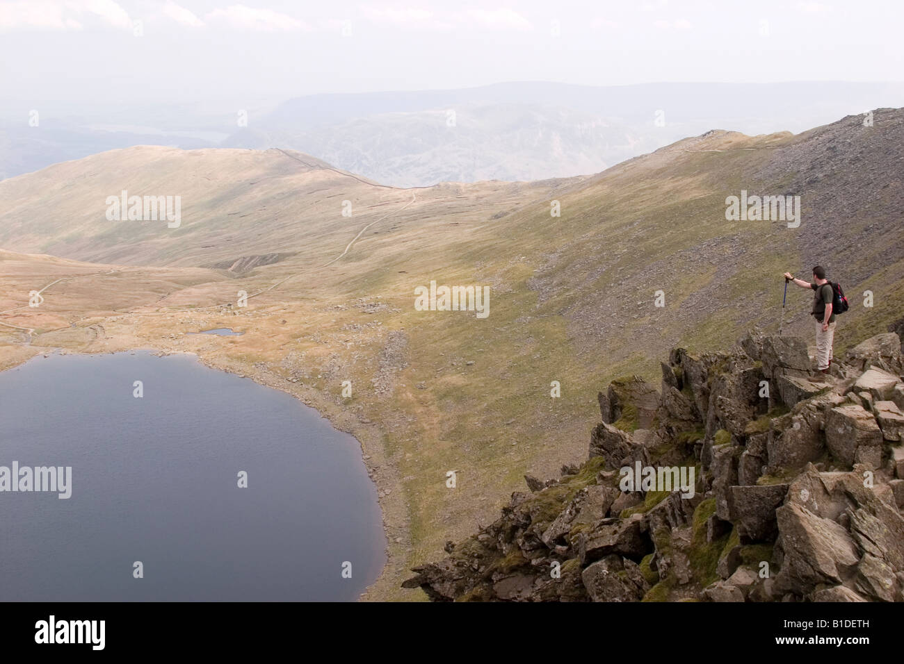 Walker with walking pole looking over Red Tarn from Striding Edge ...