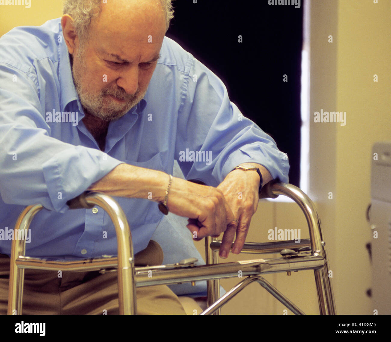 Disabled elderly male patient with orthopedic walker sitting alone in ...