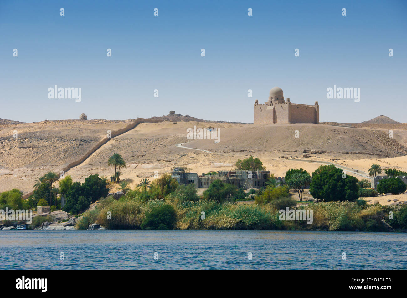 An islamic mosque on a hill across the Nile river from Aswan Egypt ...