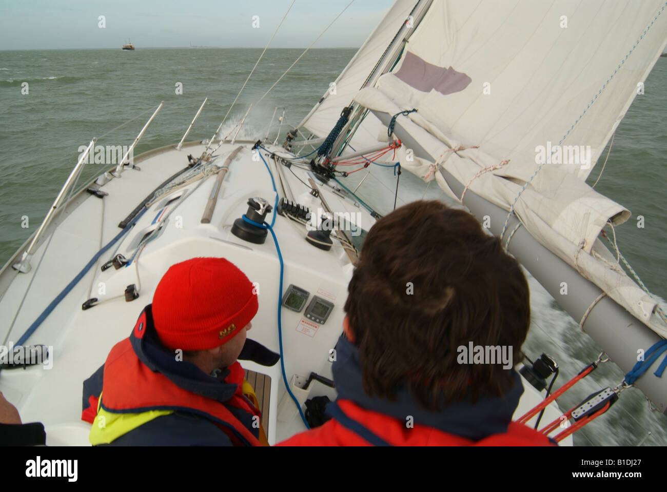 View from behind helm position of sailing yacht heeled over beating to ...