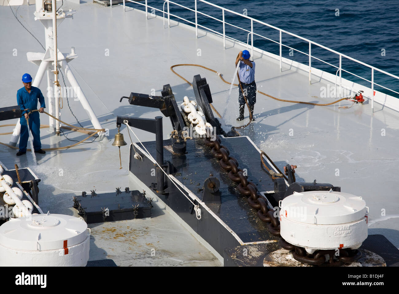 Cunard QE2 bow bring up the anchor chain deck hands washing the anchor ...