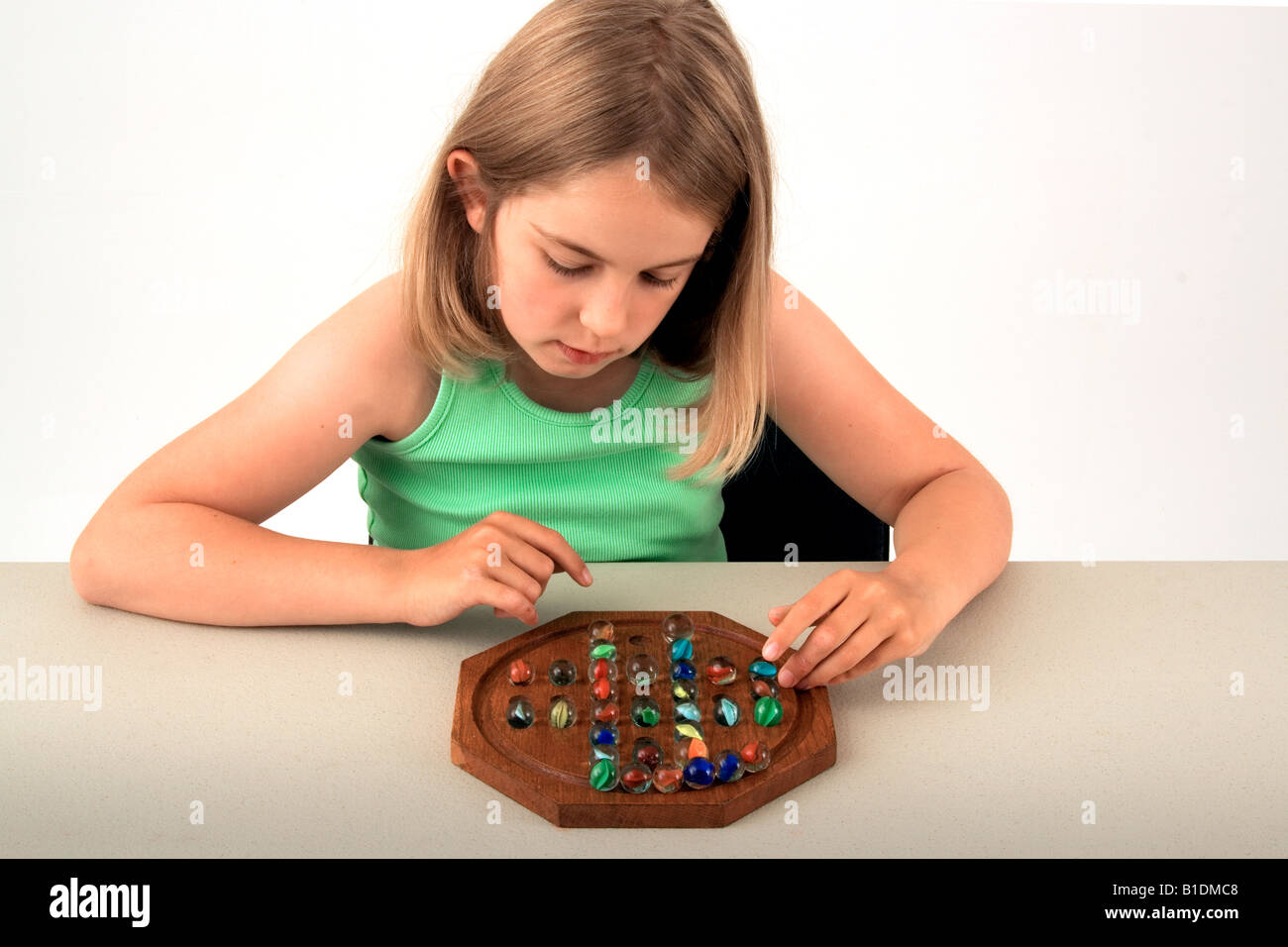 Girl playing solitaire with marbles Stock Photo - Alamy