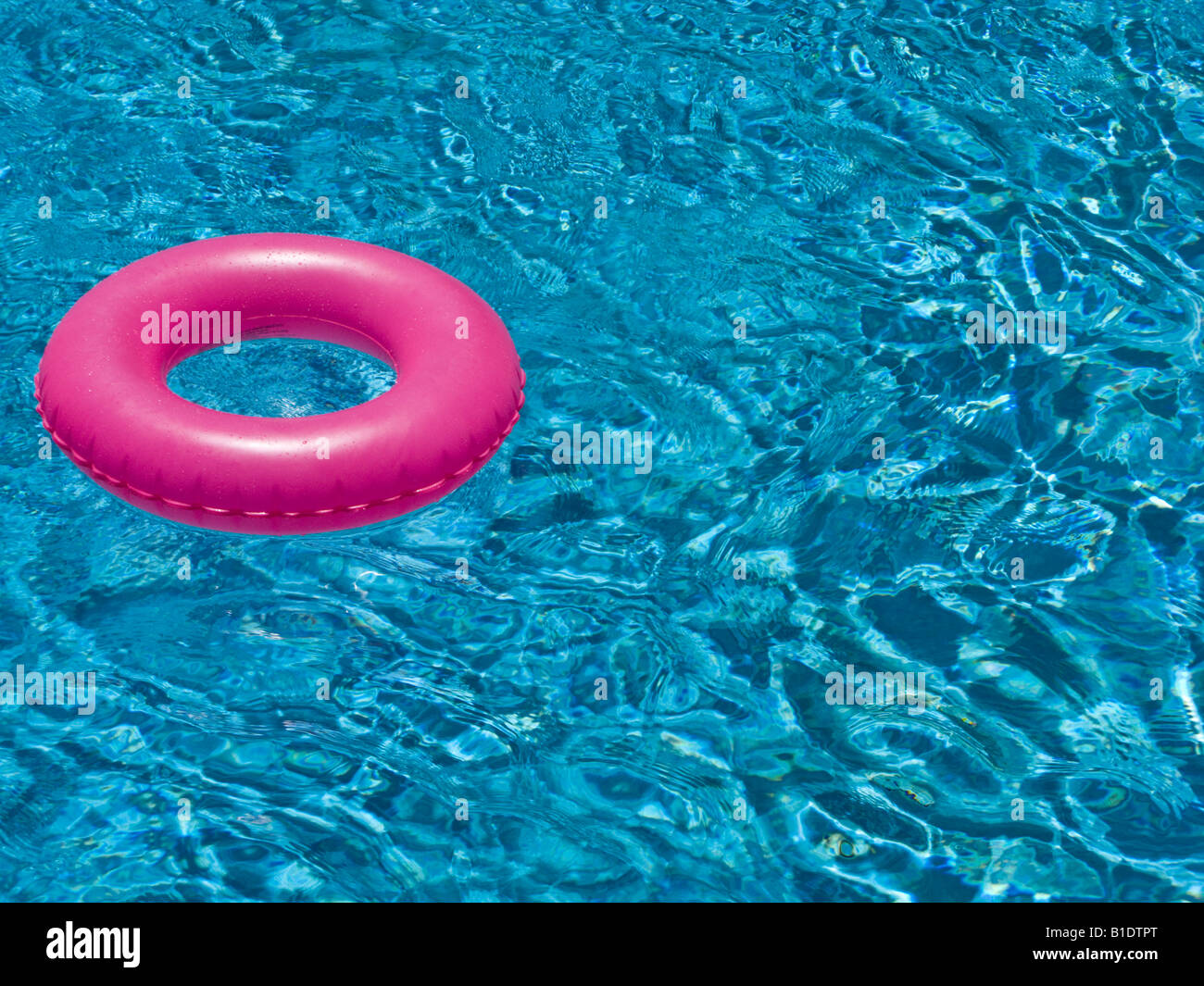 Pink inflatable ring in swimming pool Stock Photo - Alamy