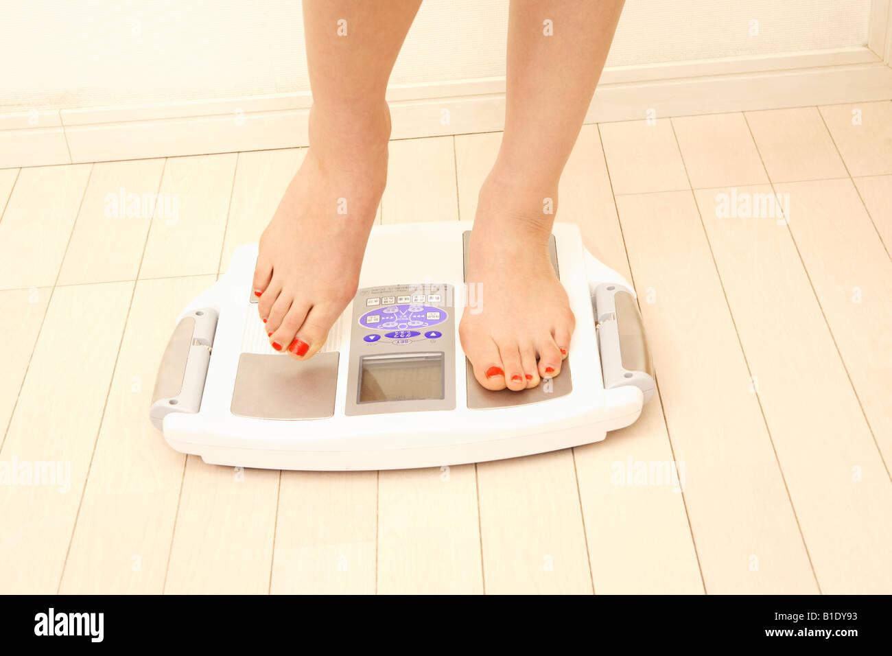 Feet stepping on the scales Stock Photo - Alamy