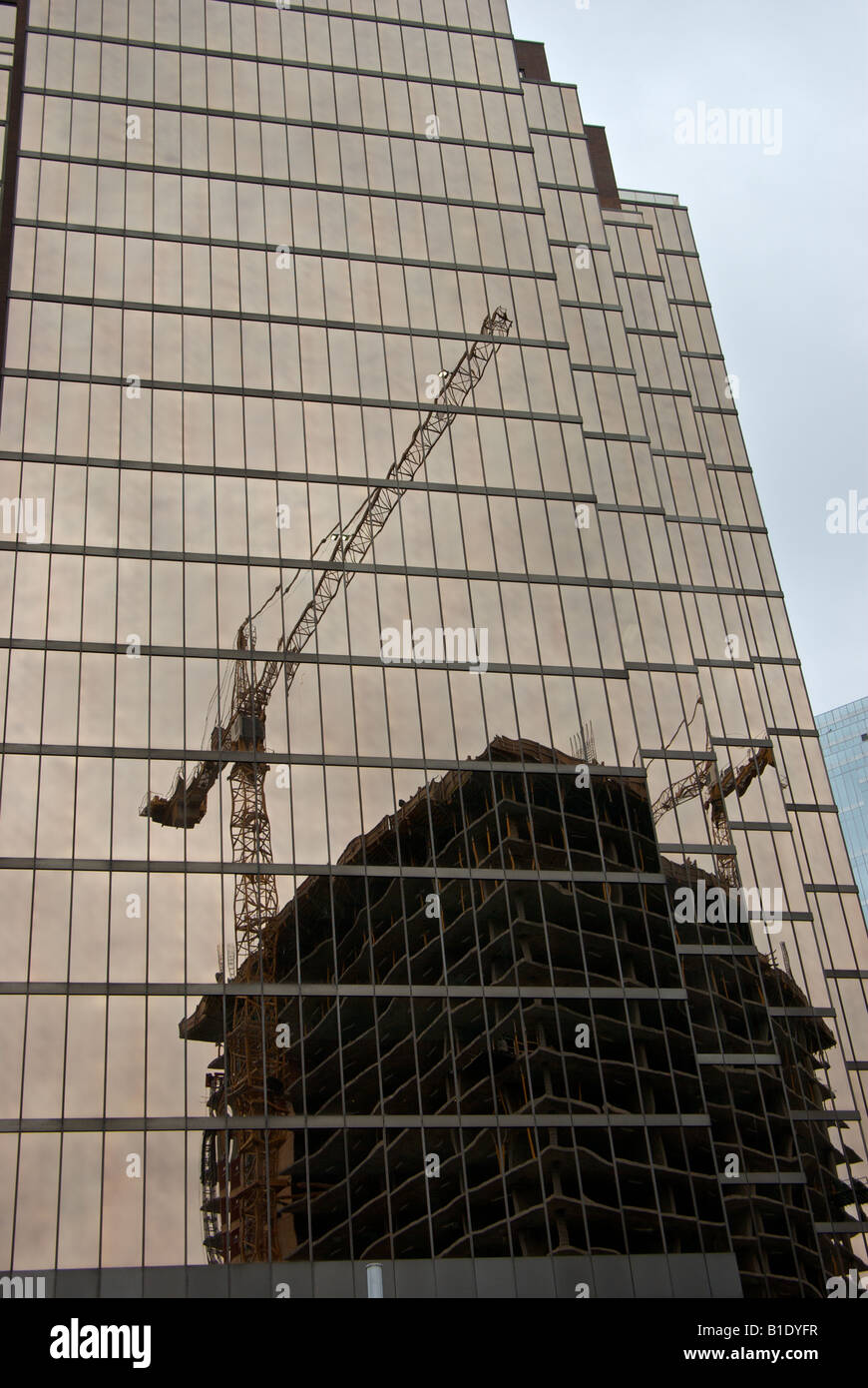 Sky crane and high rise building construction site reflection in mirror ...