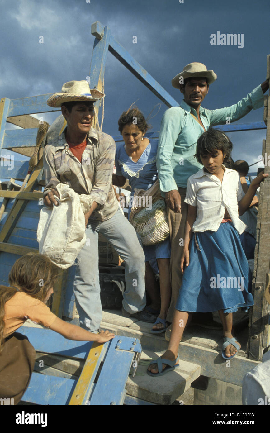 Poor displaced farmers getting off a truck at a La Vertud refugee camp ...
