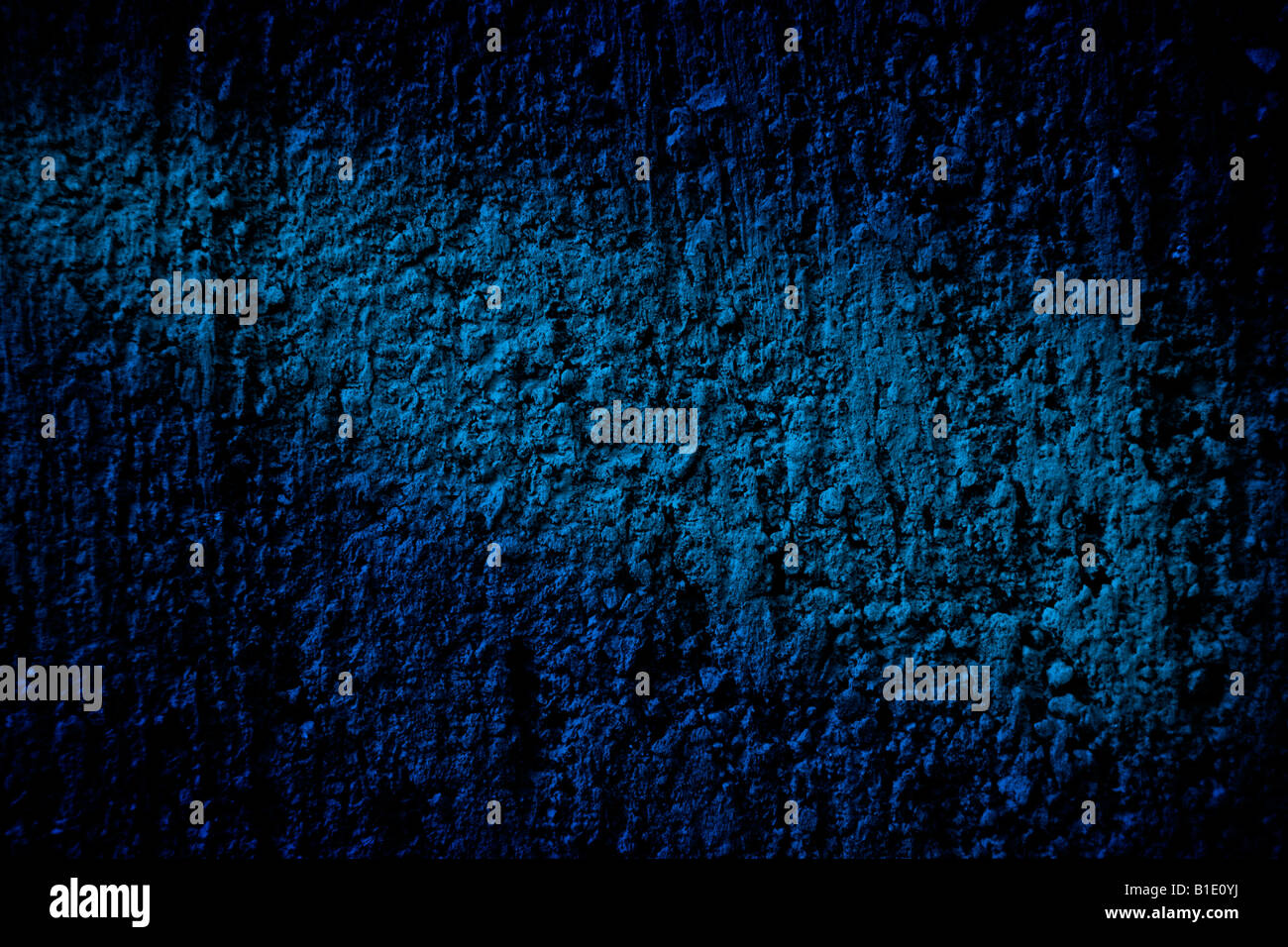 Abstract of light glow casting dark shadow on rough blue textured ...