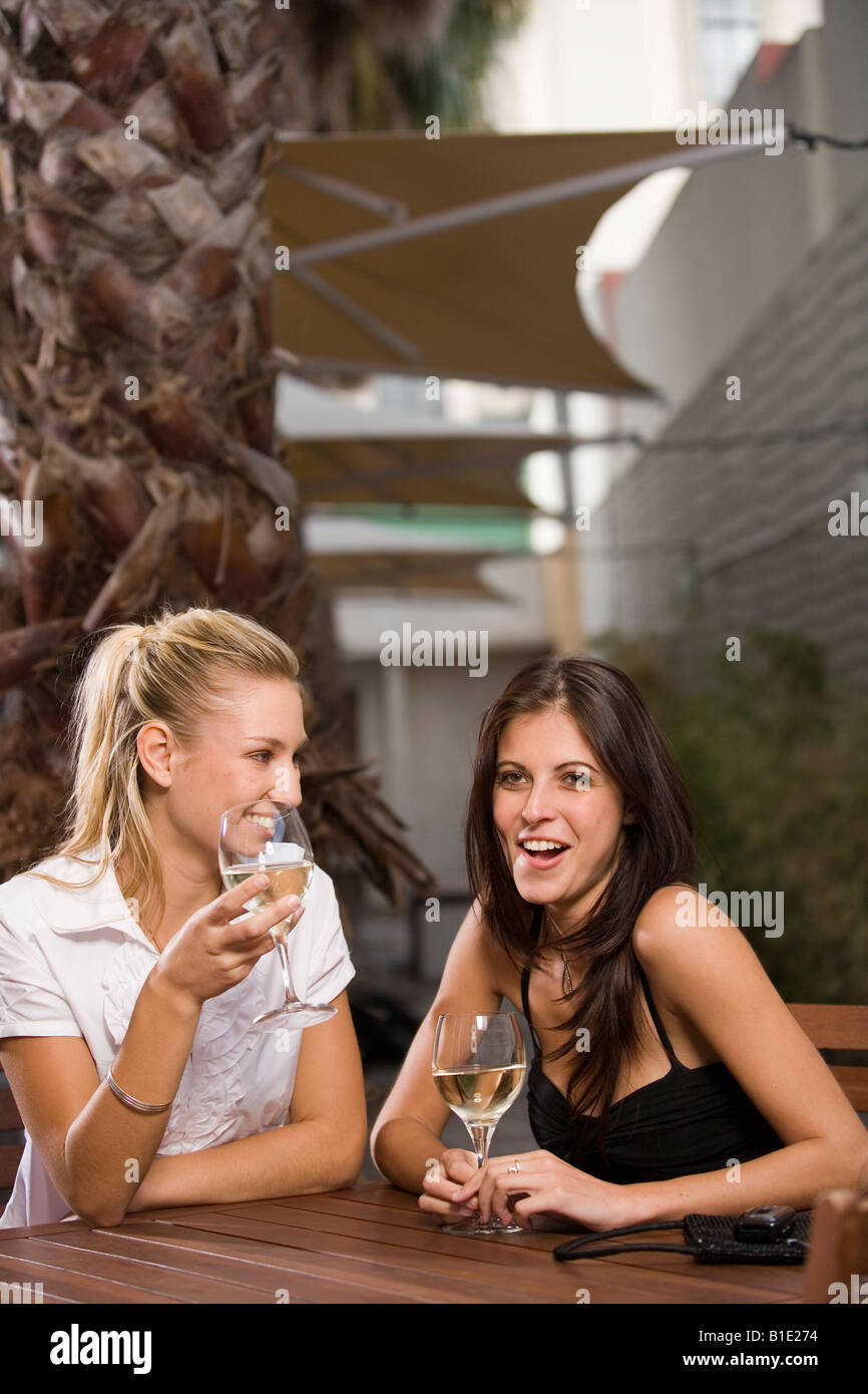 two girls sitting outside, drinking wine and talking Stock Photo - Alamy