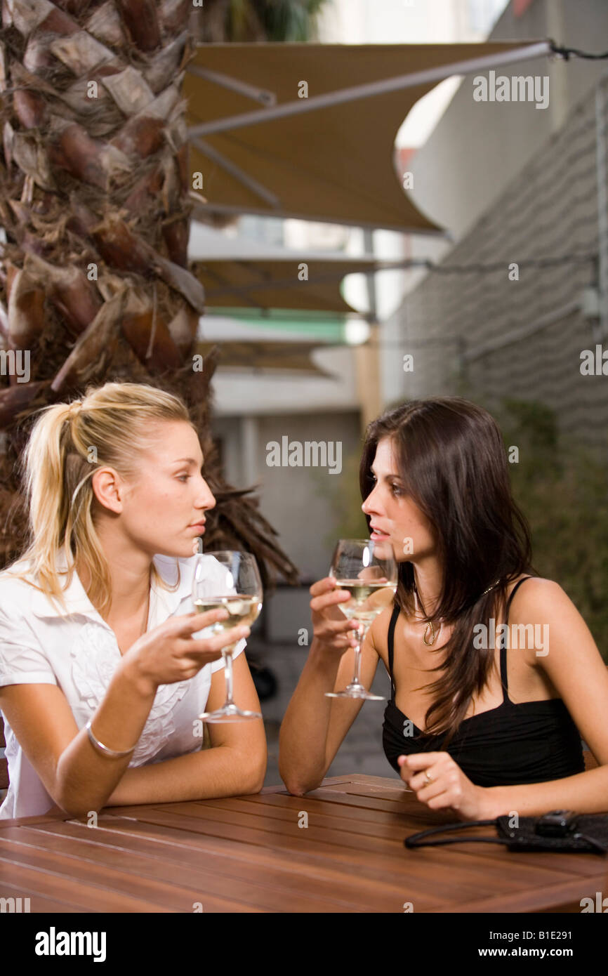 two girls sitting outside, drinking wine and talking Stock Photo - Alamy