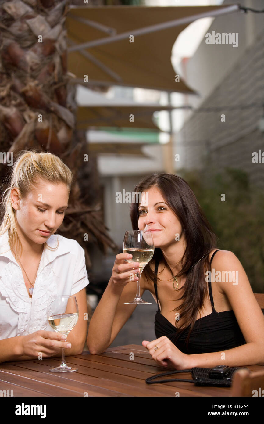 two girls sitting outside, drinking wine and talking Stock Photo - Alamy