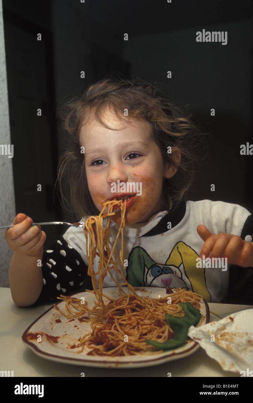 Little girl really into her spaghetti Stock Photo - Alamy