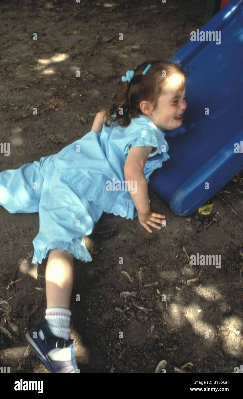 Upset nursery school child at the bottom of a slide Stock Photo - Alamy