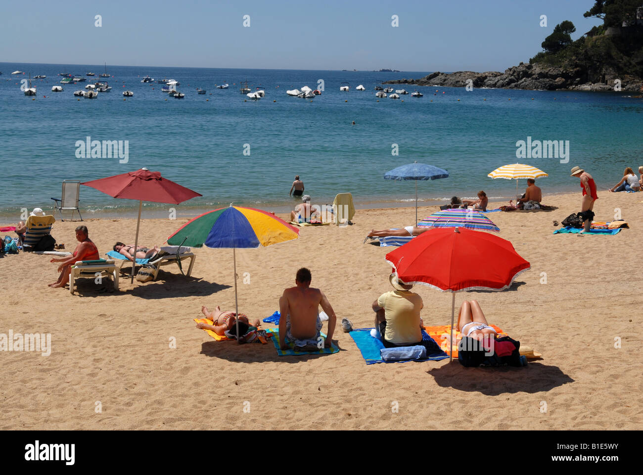 Sun bathers on the beach at Llafranc Palafrugell on the Costa Brava ...