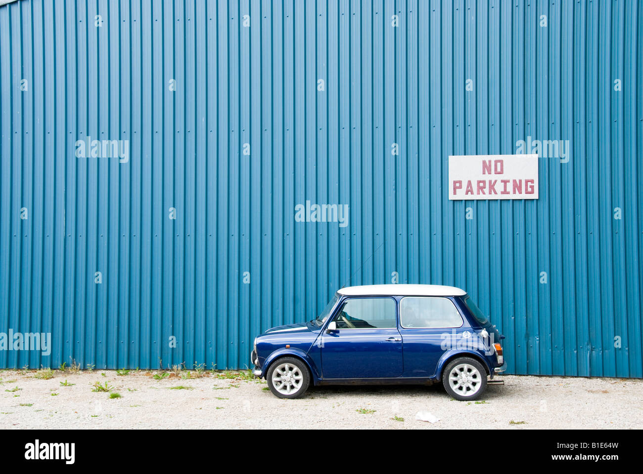 blue mini cooper parked under no parking sign Stock Photo - Alamy