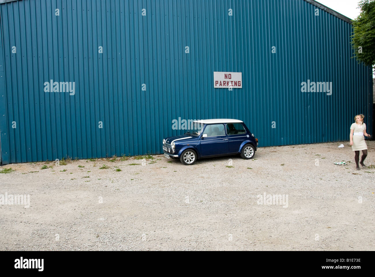 blonde teenage girl parking mini cooper underneath no parking sign ...