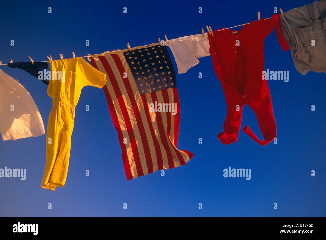 US Flag & Clothing on clothes line blowing in the wind against blue sky ...