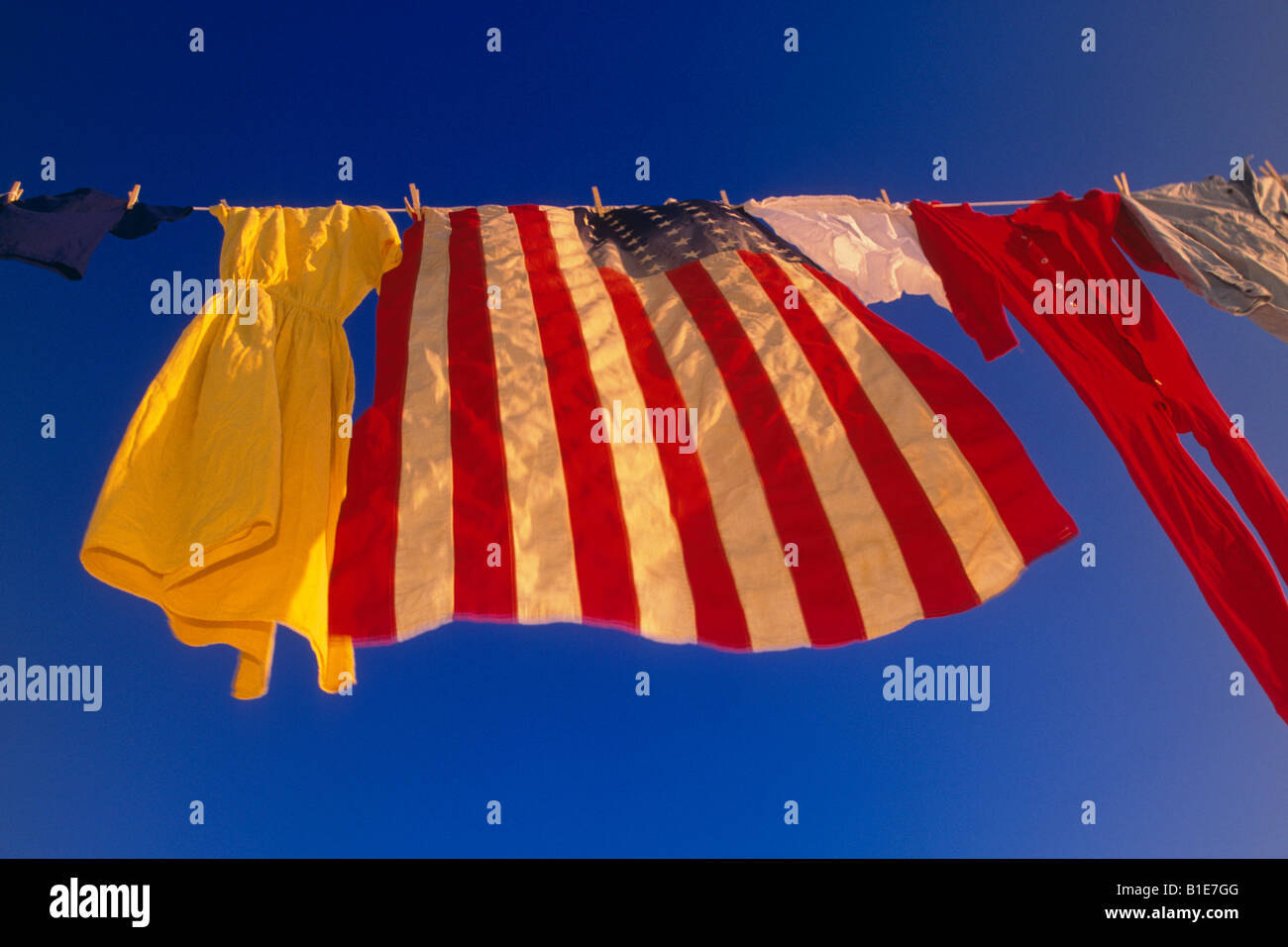 US Flag & Clothing on clothes line blowing in the wind against blue sky ...