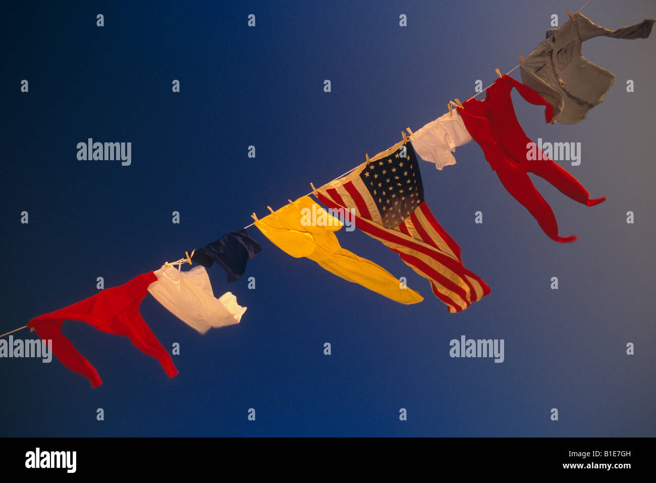 US Flag & Clothing on clothes line blowing in the wind against blue sky ...