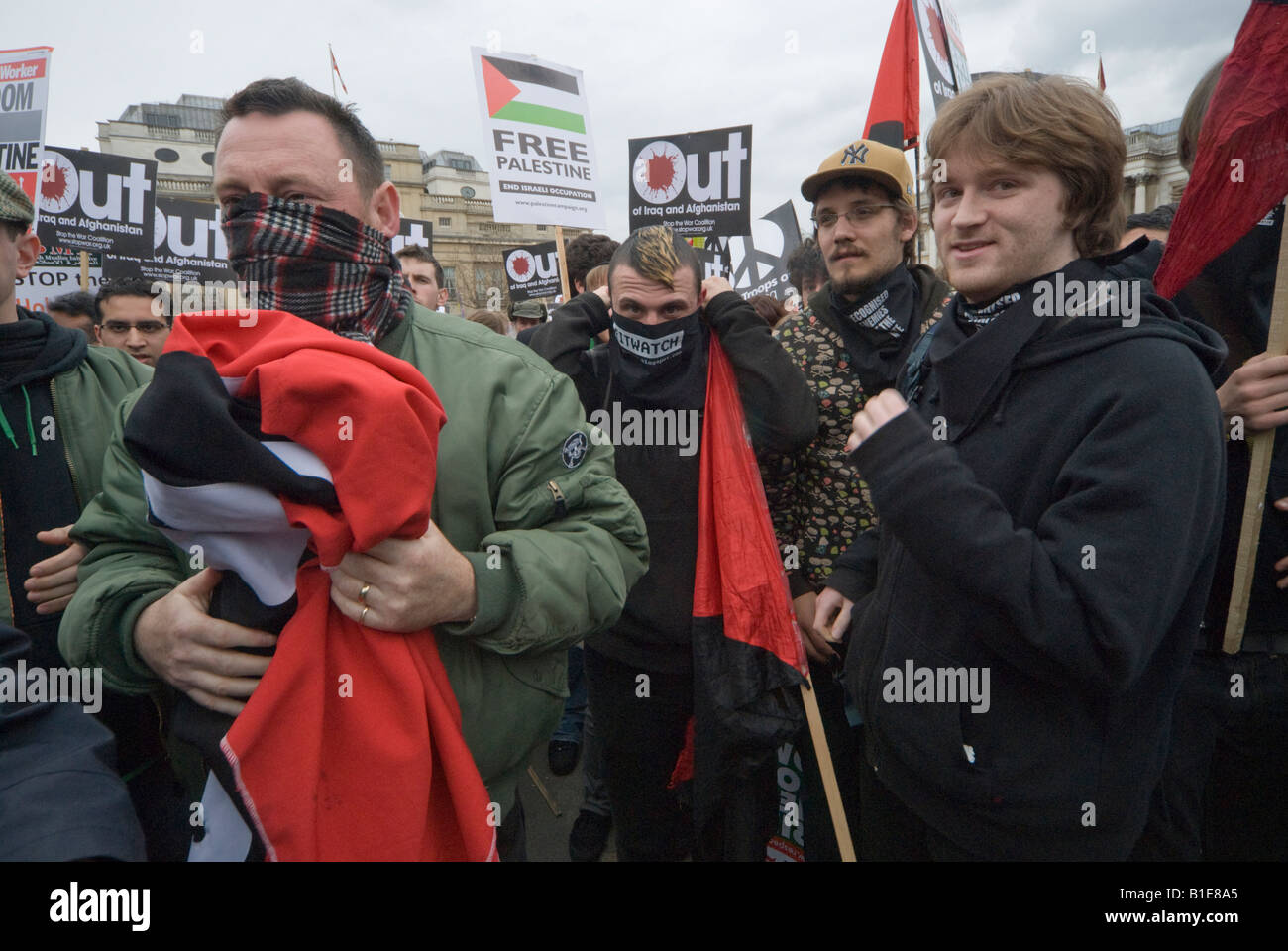 Anarchists, some wearing masks, in front of the platform at the rally ...