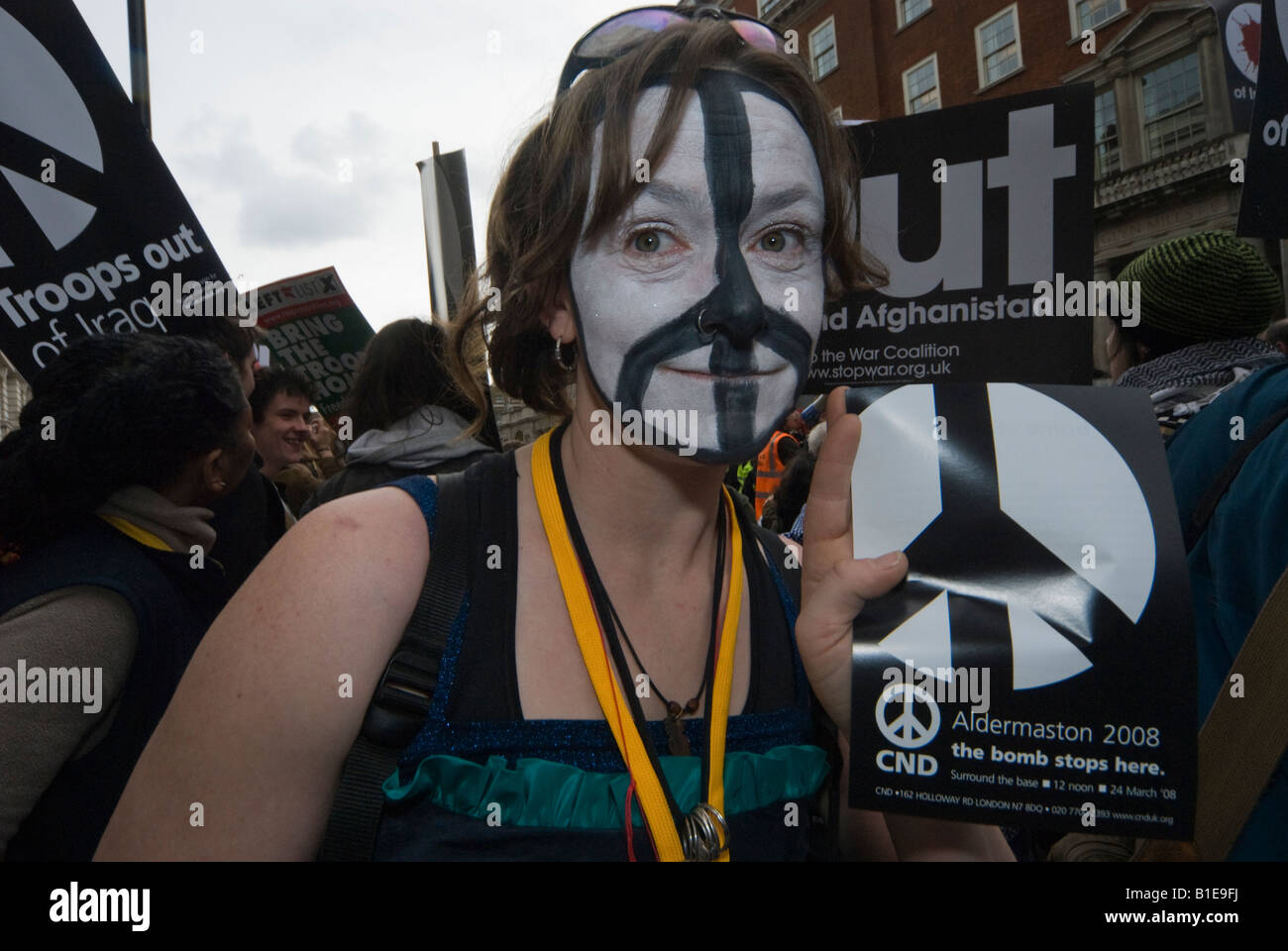 Woman with face painted with CND symbol hold flier with the same symbol ...