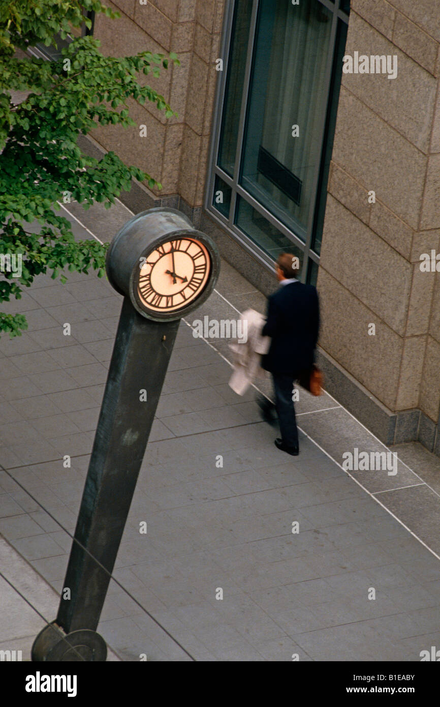 Blurred image of man walking down city sidewalk near clock Seattle ...