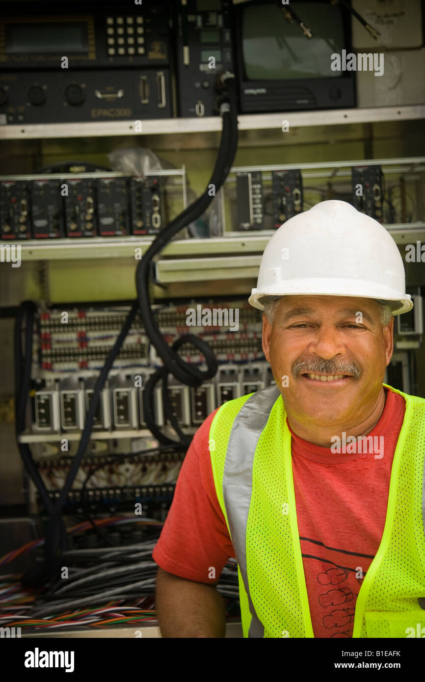 Hispanic male construction worker wearing a hard hat and safety vest ...