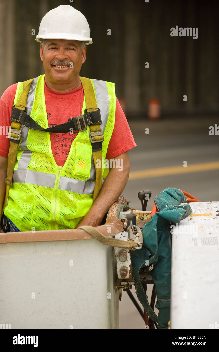 Male Hispanic construction worker smiling at the camera while working ...