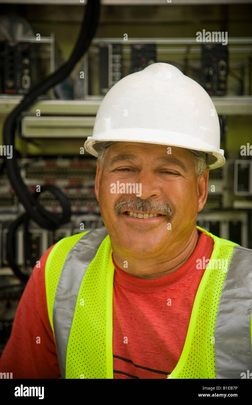 Hispanic male construction worker wearing a hard hat and safety vest ...