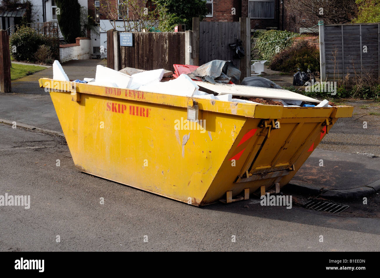 Yellow skip on the side of the road Stock Photo - Alamy