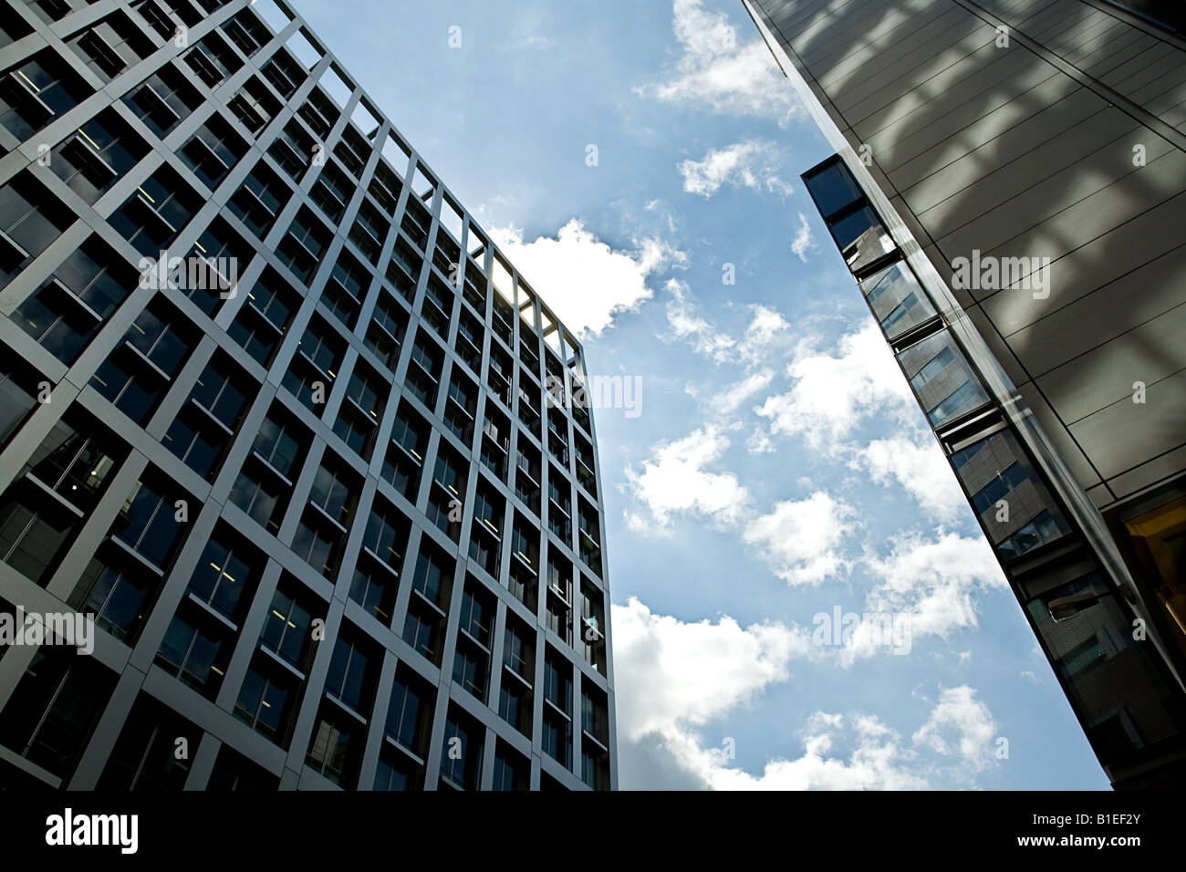 Looking up at high office buildings with cloudy sky Stock Photo - Alamy