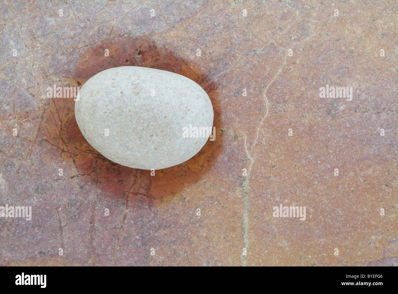 One pebble on a large rock in an abstract design Stock Photo - Alamy