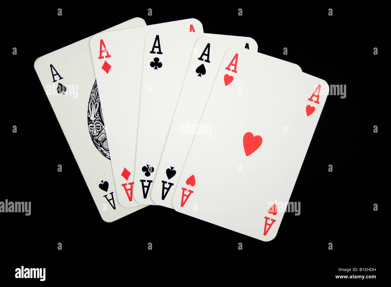 Five aces dealt in a hand of playing cards isolated on a black ...